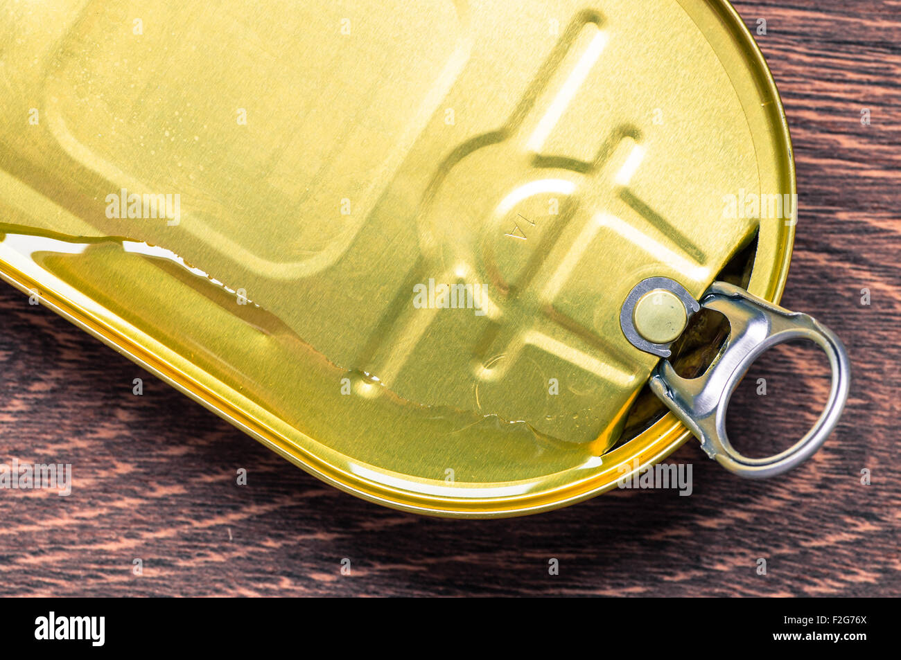 Oil flows when opening a tin can top view Stock Photo - Alamy