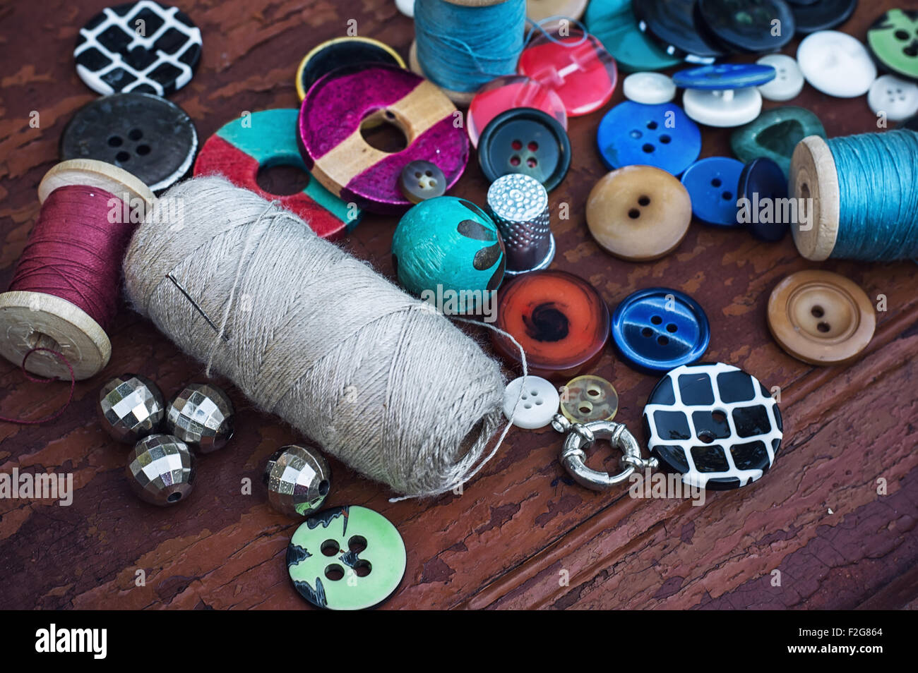 set of threads and buttons on old wooden background Stock Photo - Alamy
