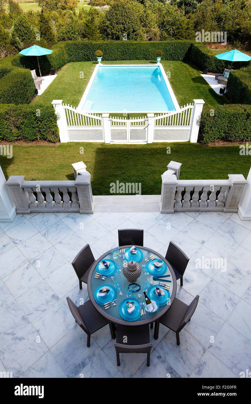 Elegant dining area on terrace overlooking swimming pool Stock Photo ...