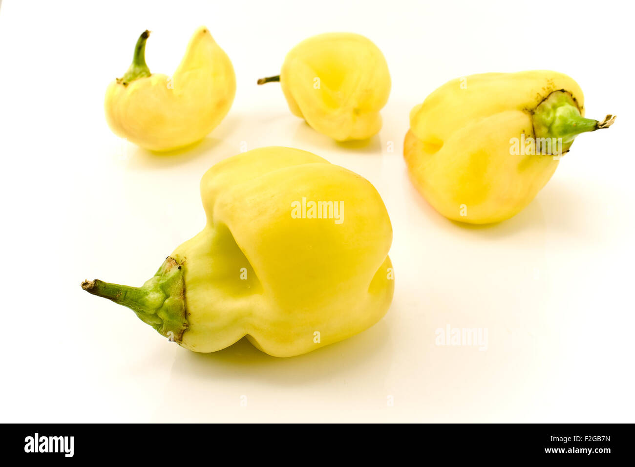 Deformed yellow paprika peppers on white background Stock Photo - Alamy