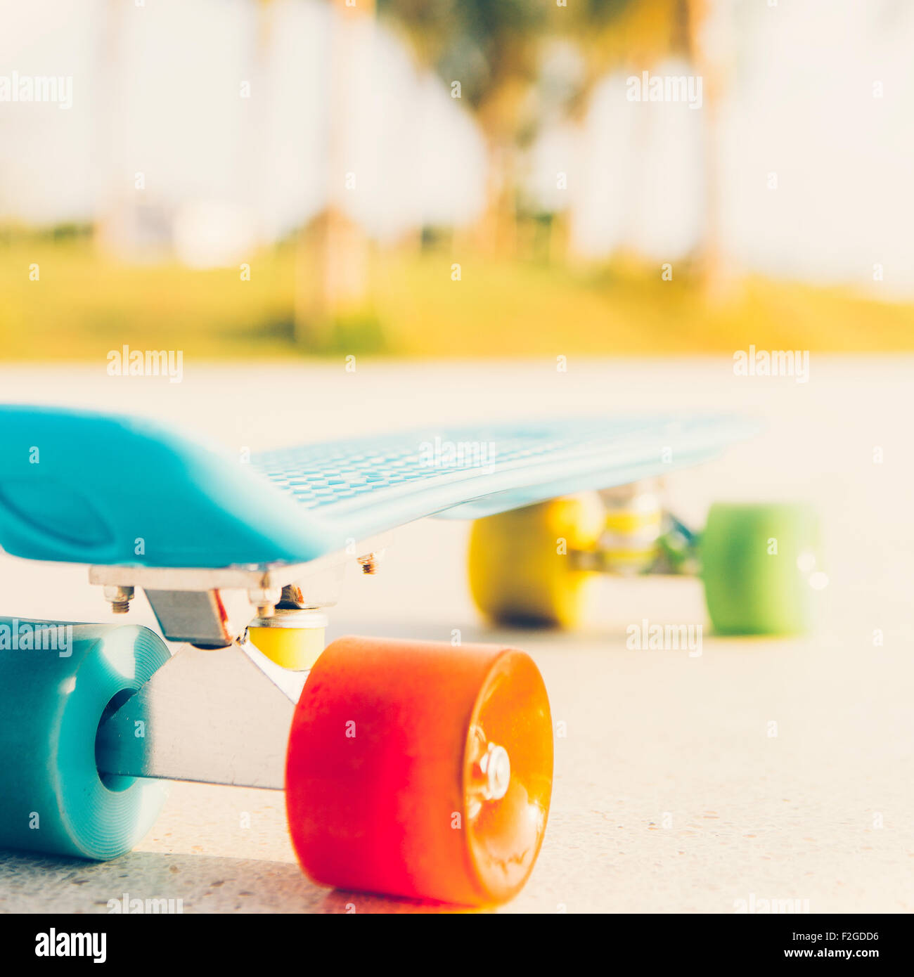 blue penny board with multicolored wheels stands on the track in front ...