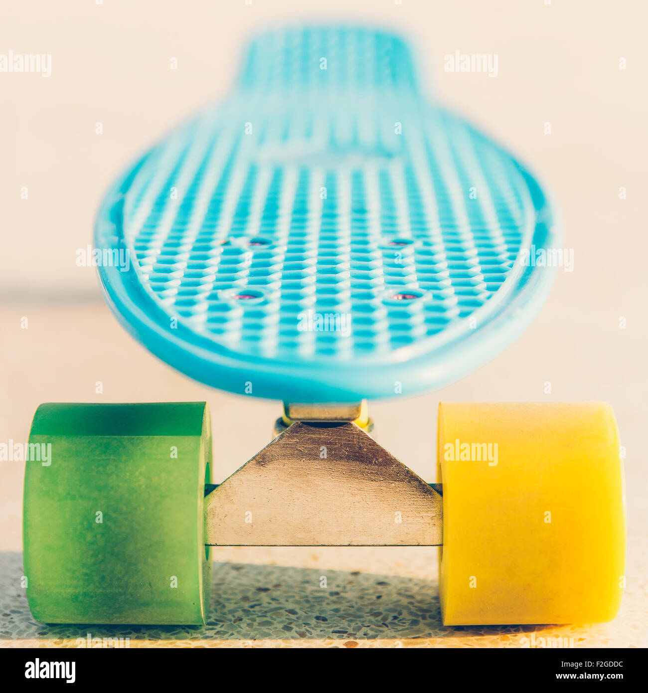 front view of the blue penny board with multicolored wheels stands on ...