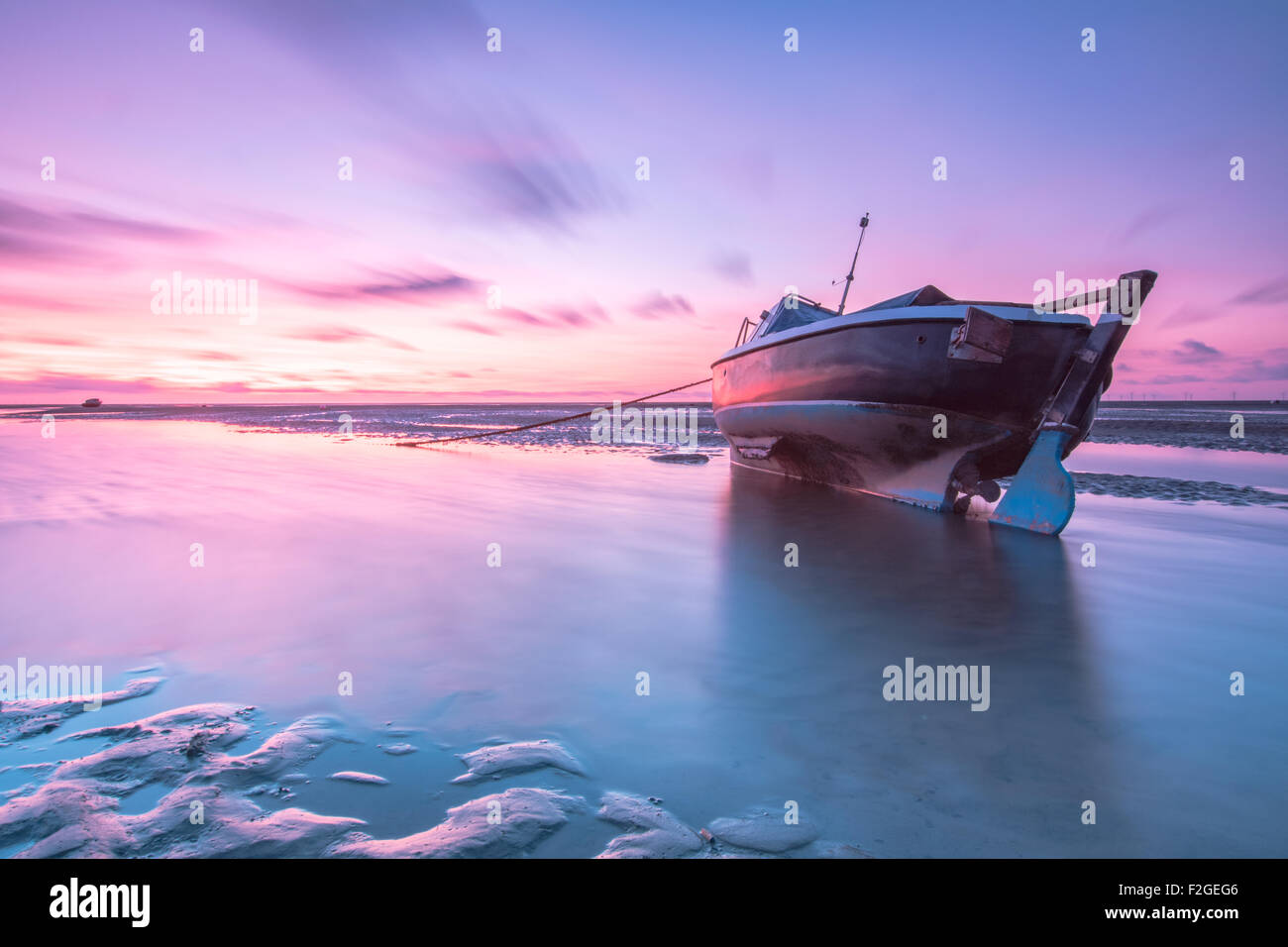 Boat on a sunset beach Stock Photo - Alamy