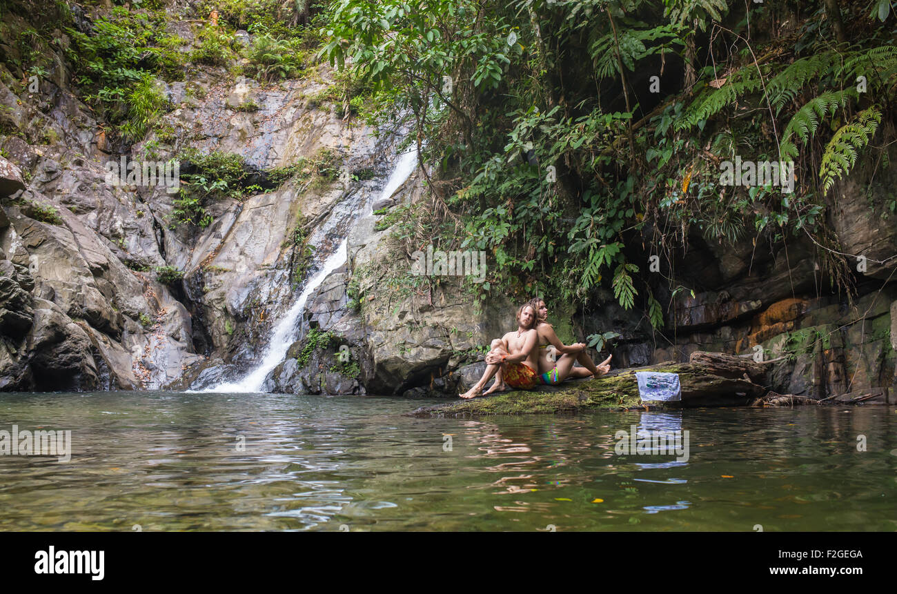 Cheerful couple enjoying river bath by waterfall Stock Photo - Alamy