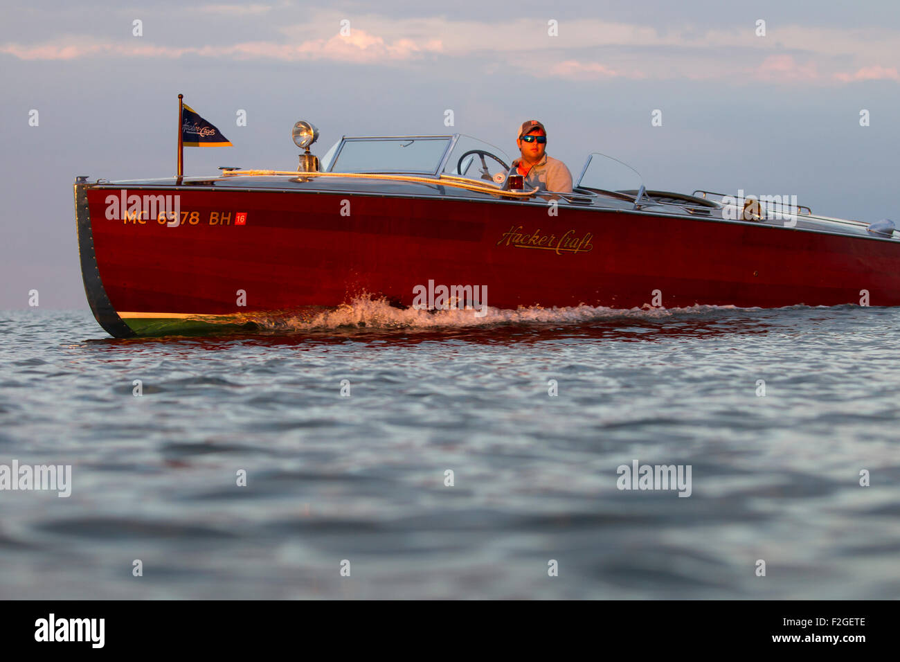 A man slowly cruising in an antique, wood speedboat Stock Photo - Alamy
