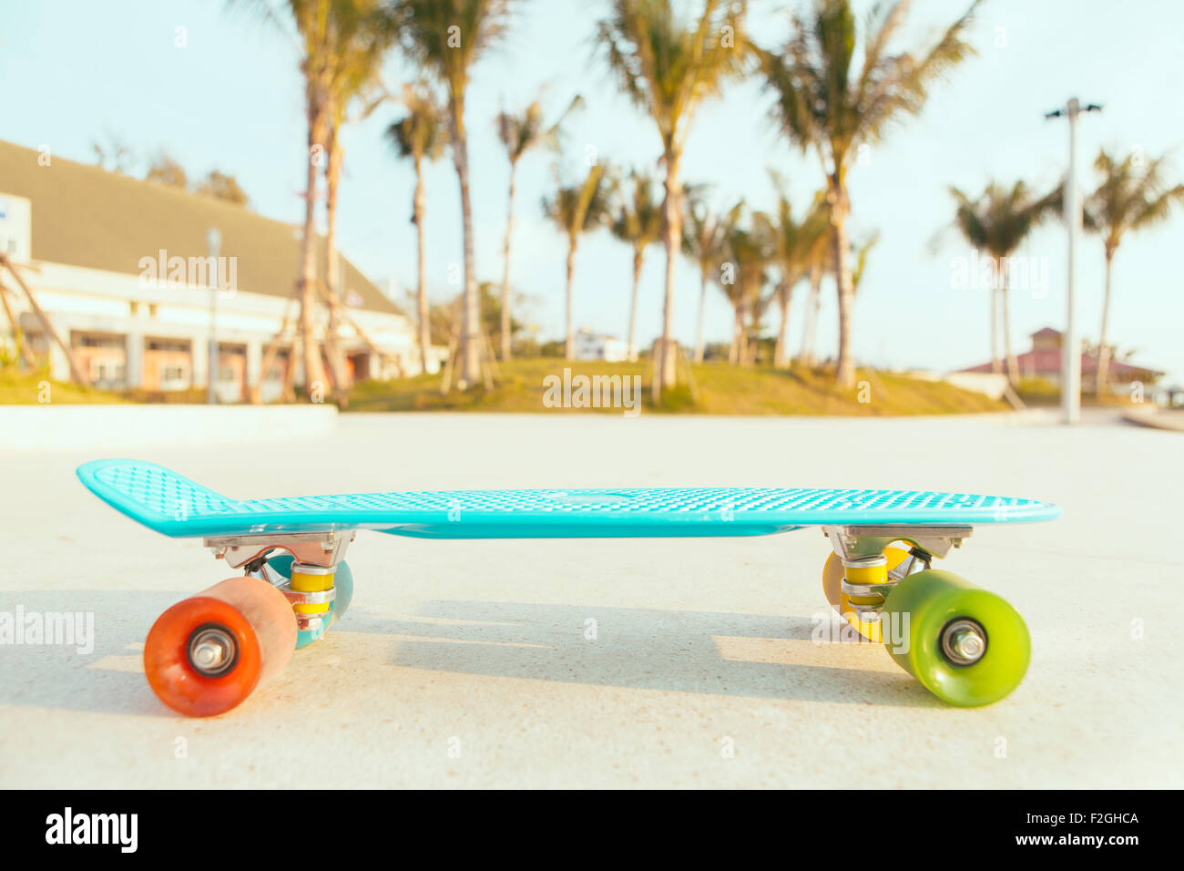 blue penny board with multicolored wheels stands on the track in front ...