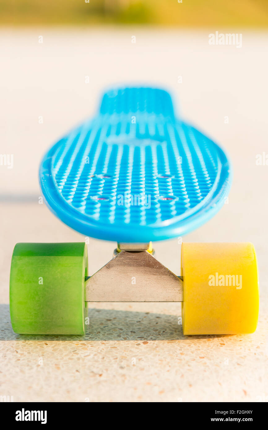 front view of the blue penny board with multicolored wheels stands on ...