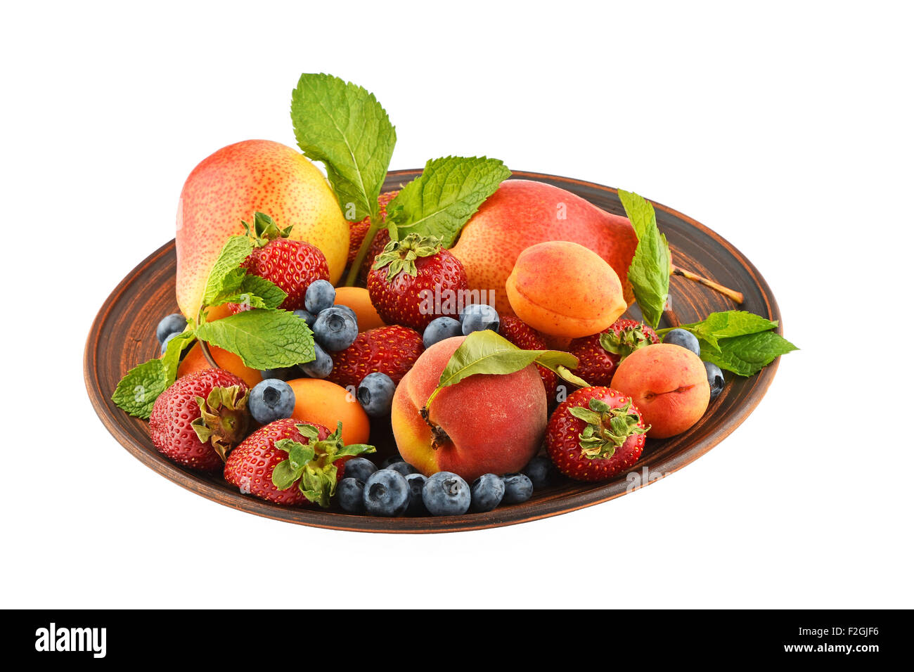 Mellow fresh summer fruits and berries mix with mint leaves in ceramic ...