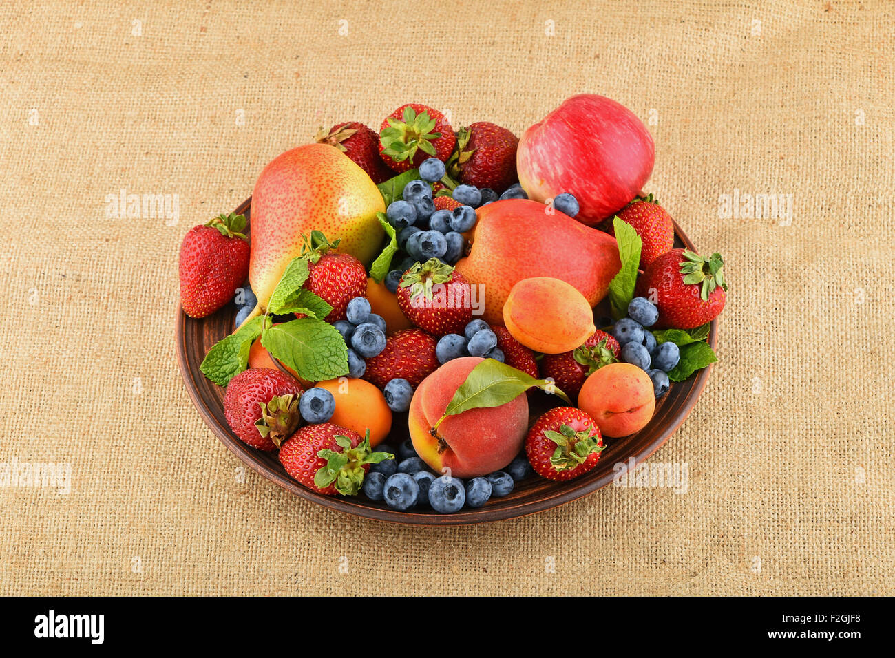 Mellow fresh summer fruits and berries mix with mint leaves in ceramic ...