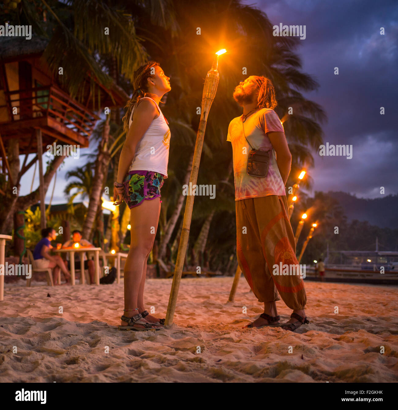 Red toned picture of a couple on tropical beach at sunset Stock Photo ...