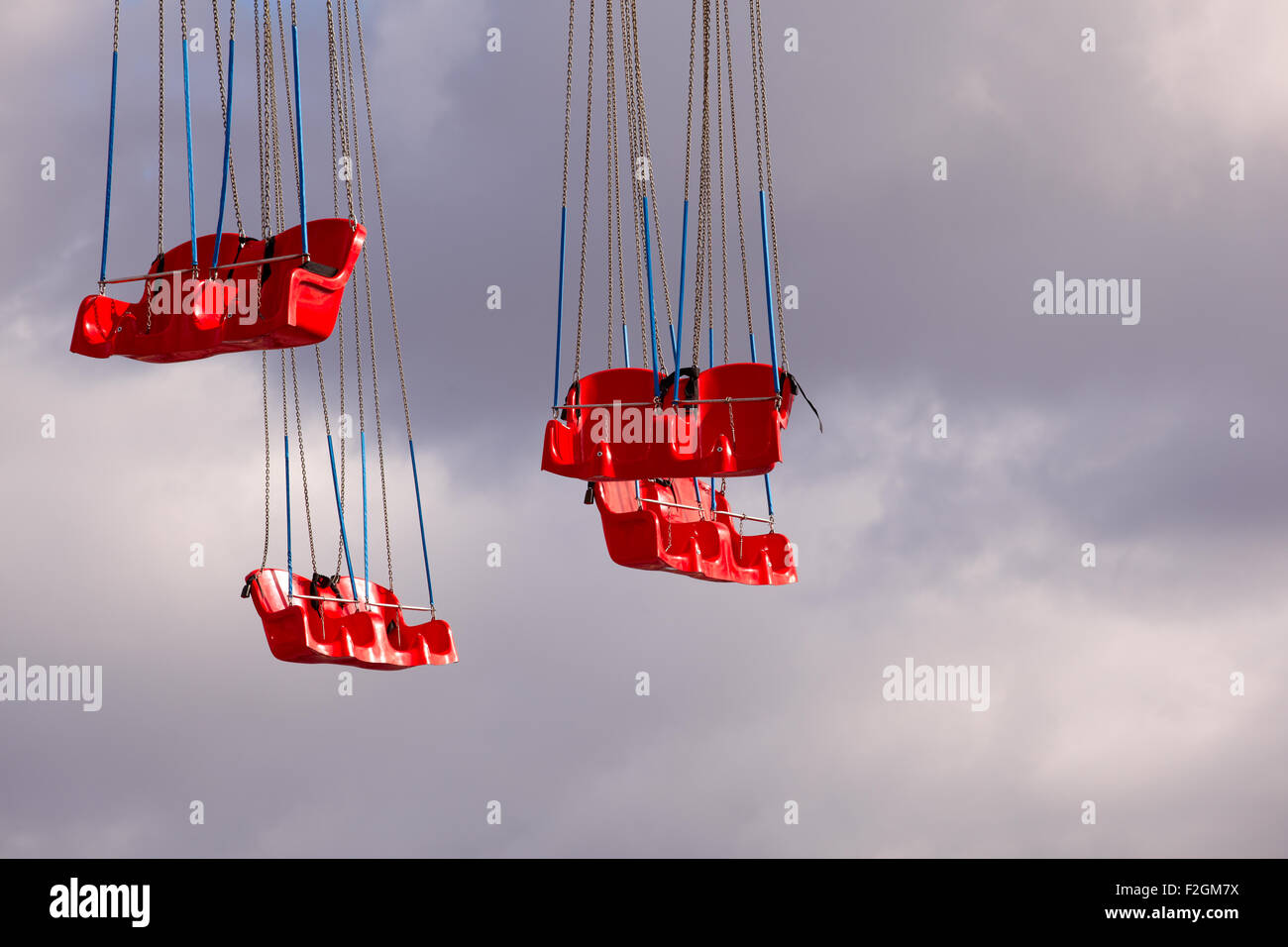 Red Carousel seats on cloudy sky Stock Photo - Alamy