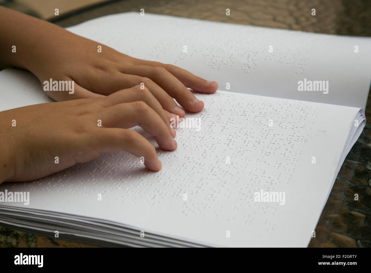 fingers reading on a braille written book Stock Photo - Alamy