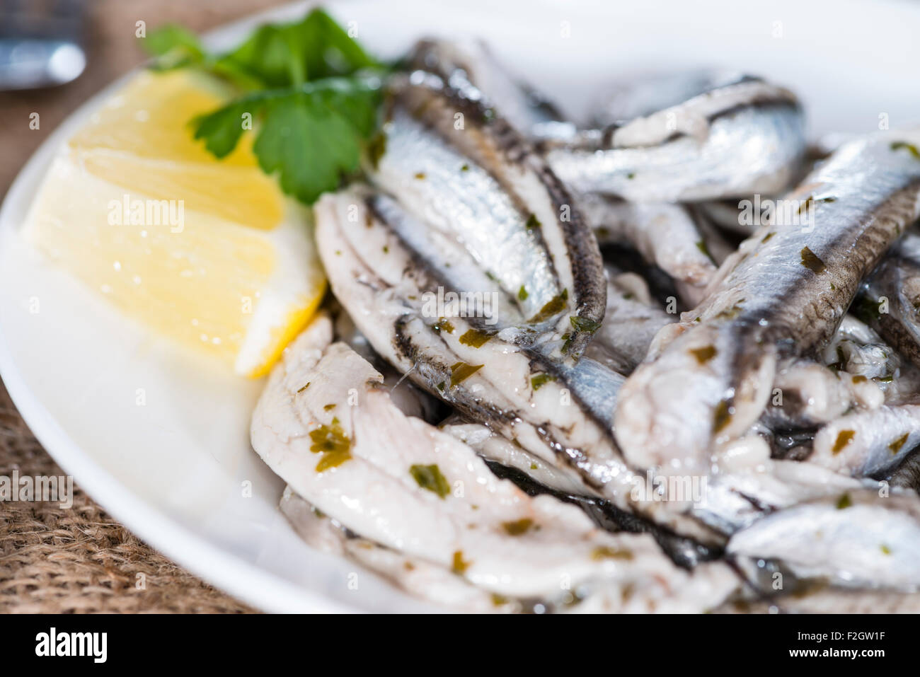 Portion of Anchovis with herbs (close-up shot Stock Photo - Alamy