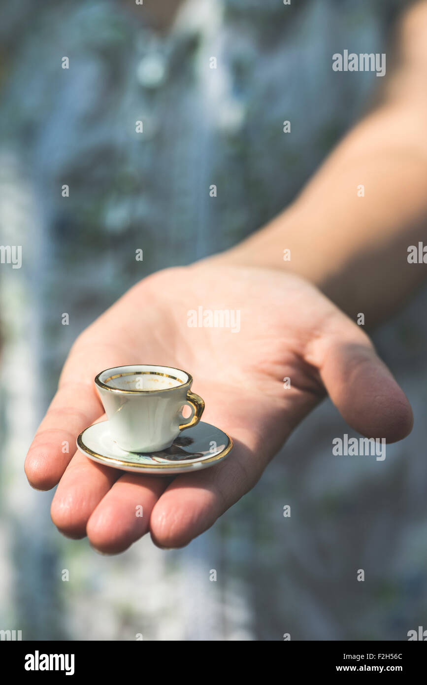 Hand hold very small cup of coffee. Miniature cup Stock Photo - Alamy