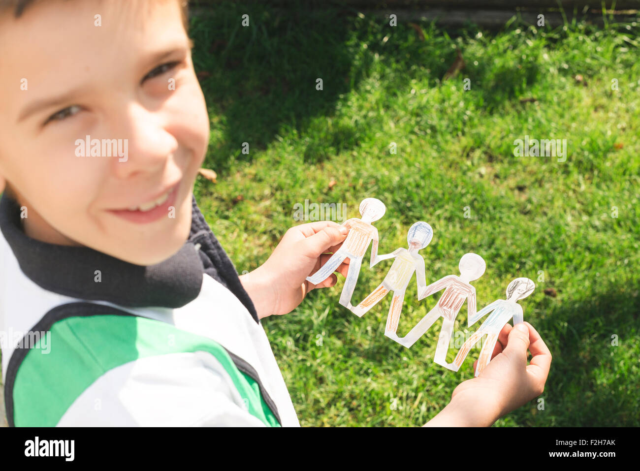 Child hold paper made people figures. Painted figures Stock Photo - Alamy