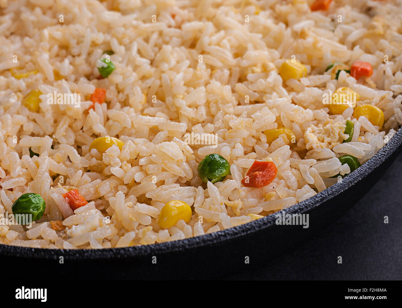 Rice with vegetable in black plate Stock Photo - Alamy