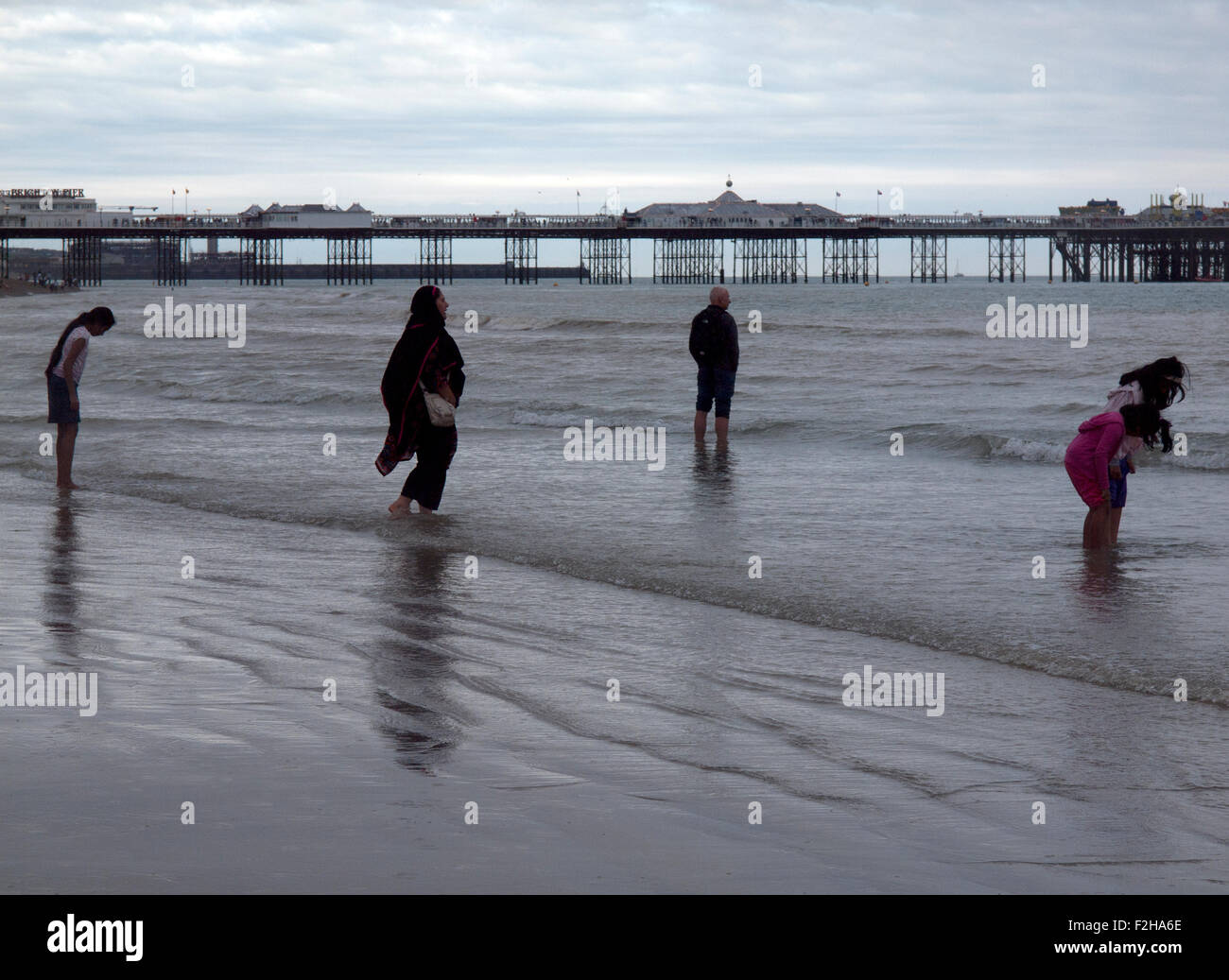 People having fun at the water's edge during a low tide in Brighton ...
