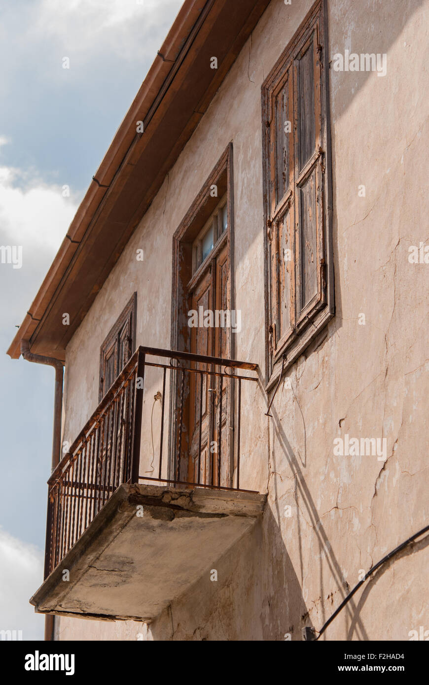 Old rusty metal balcony with the rustic shabby wooden shutters and door ...