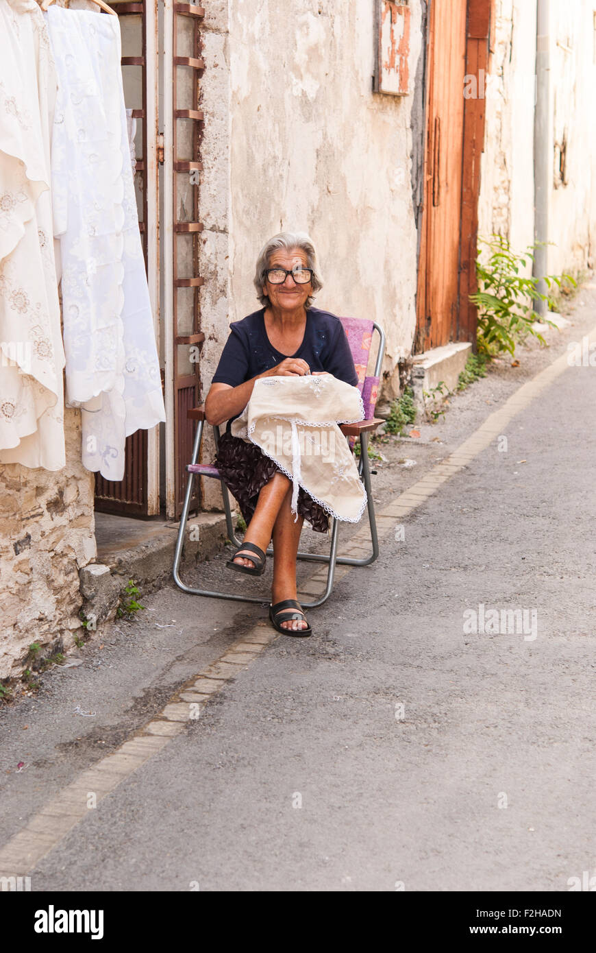 Old woman embroidering lefkaritika (traditional handmade lace) next to ...