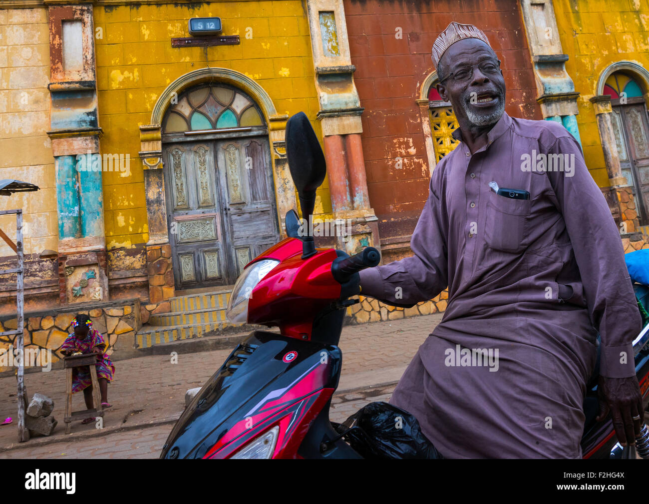 Benin, West Africa, Porto-Novo, old muslim man on a scooter in front of ...