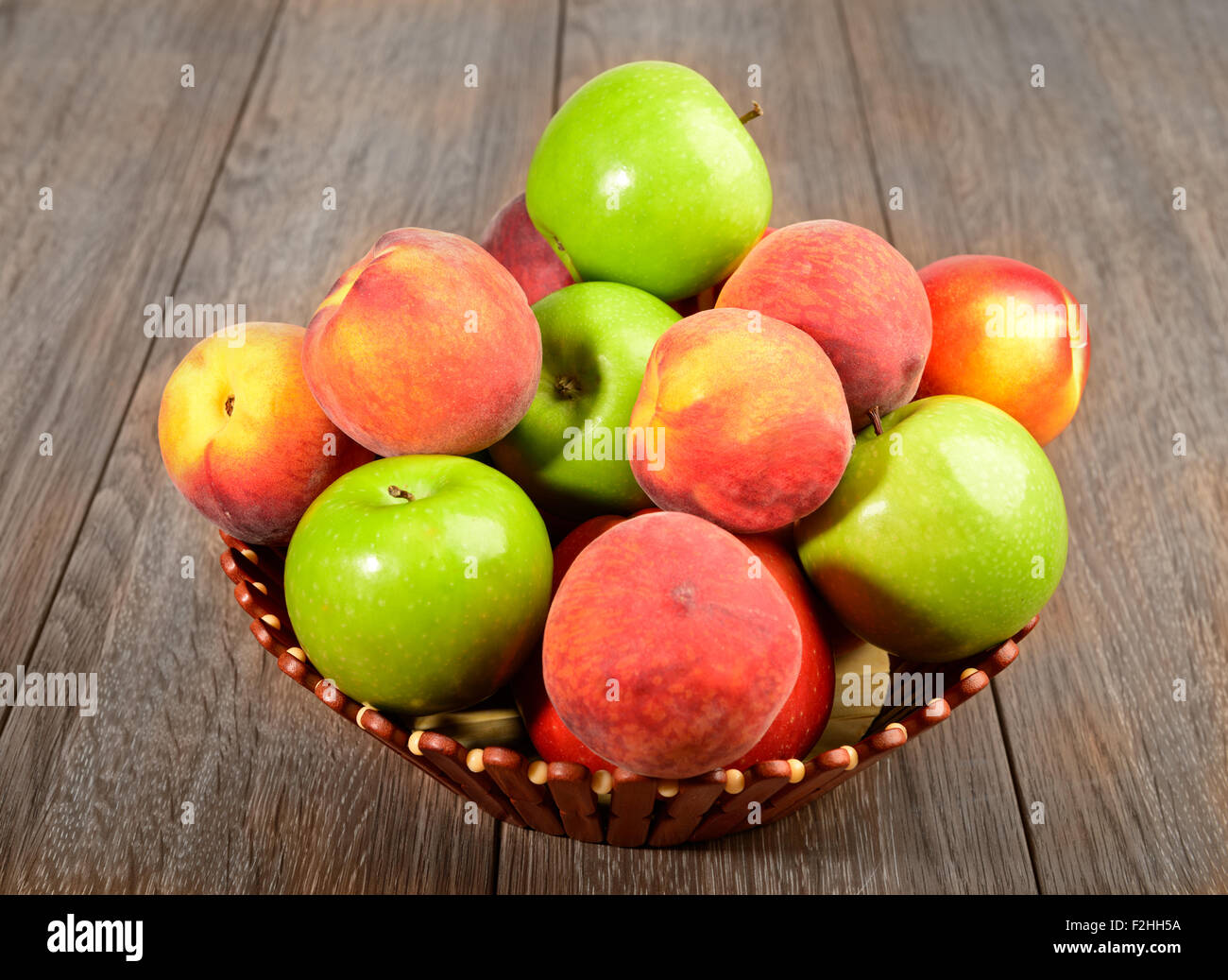 Basket with fruits apples peaches nectarines Stock Photo - Alamy