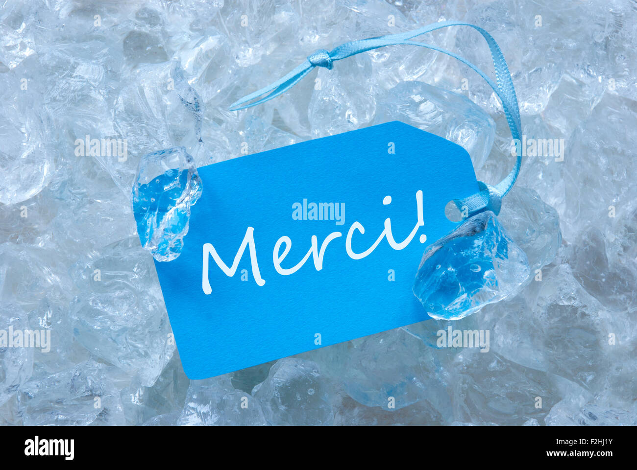 Blue Label On Ice With Merci Means Thank You Stock Photo - Alamy