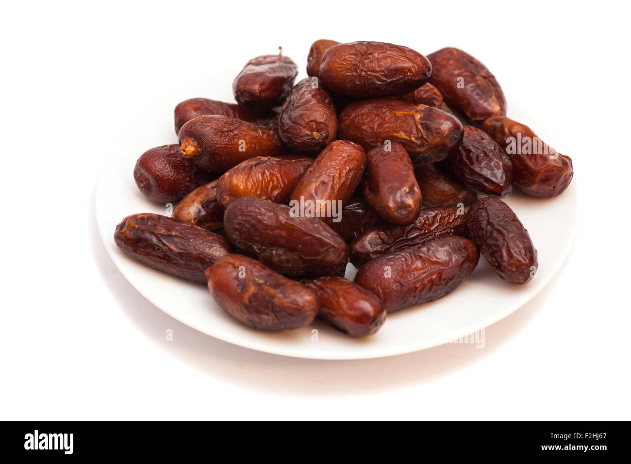 Fresh dates on white plate isolated on white background Stock Photo - Alamy