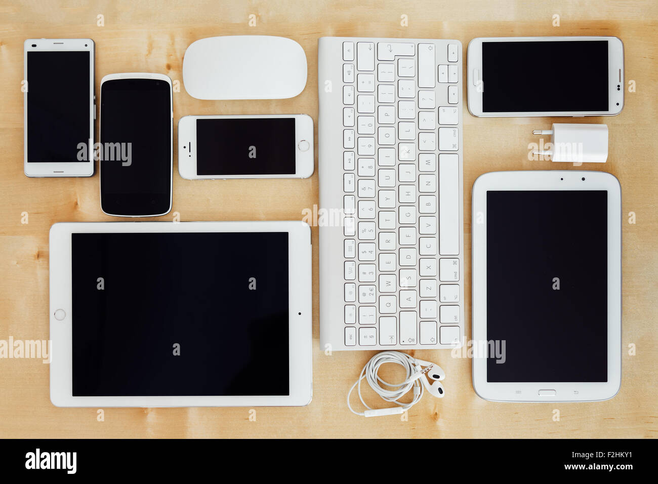 Collection of smartphones and tablets with keyboard and plug on a ...