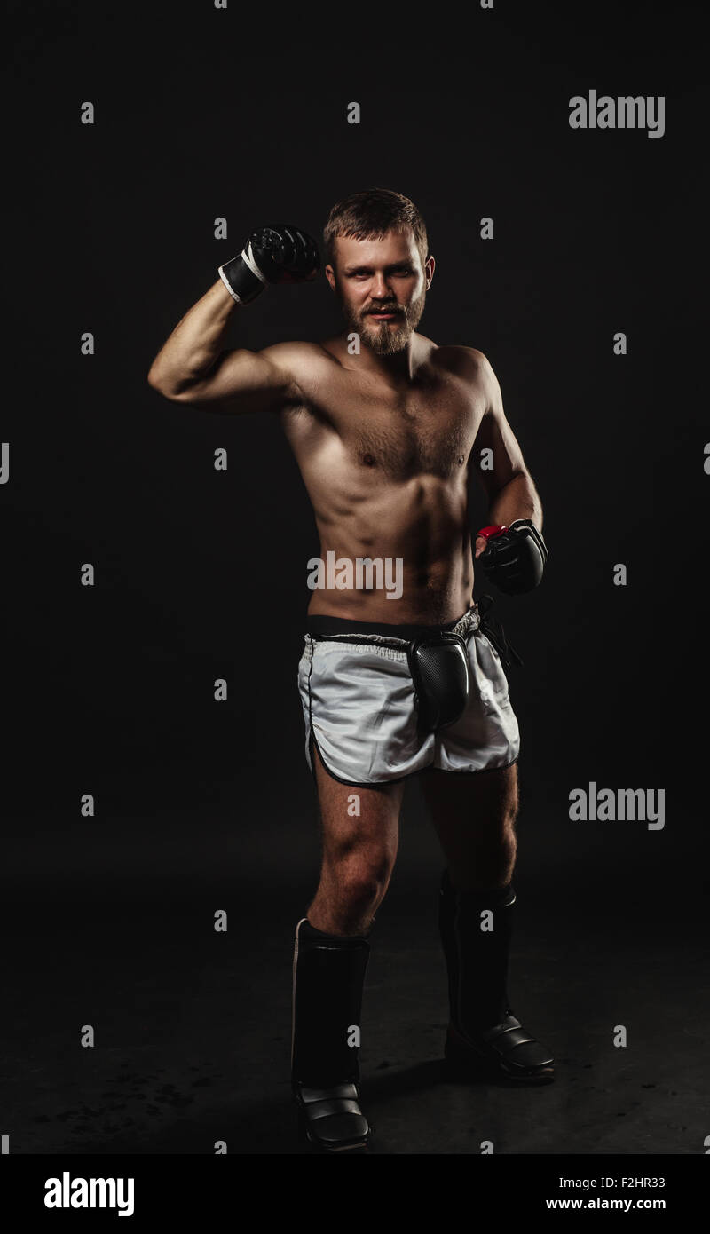 Athletic bearded boxer with gloves on a dark background Stock Photo - Alamy