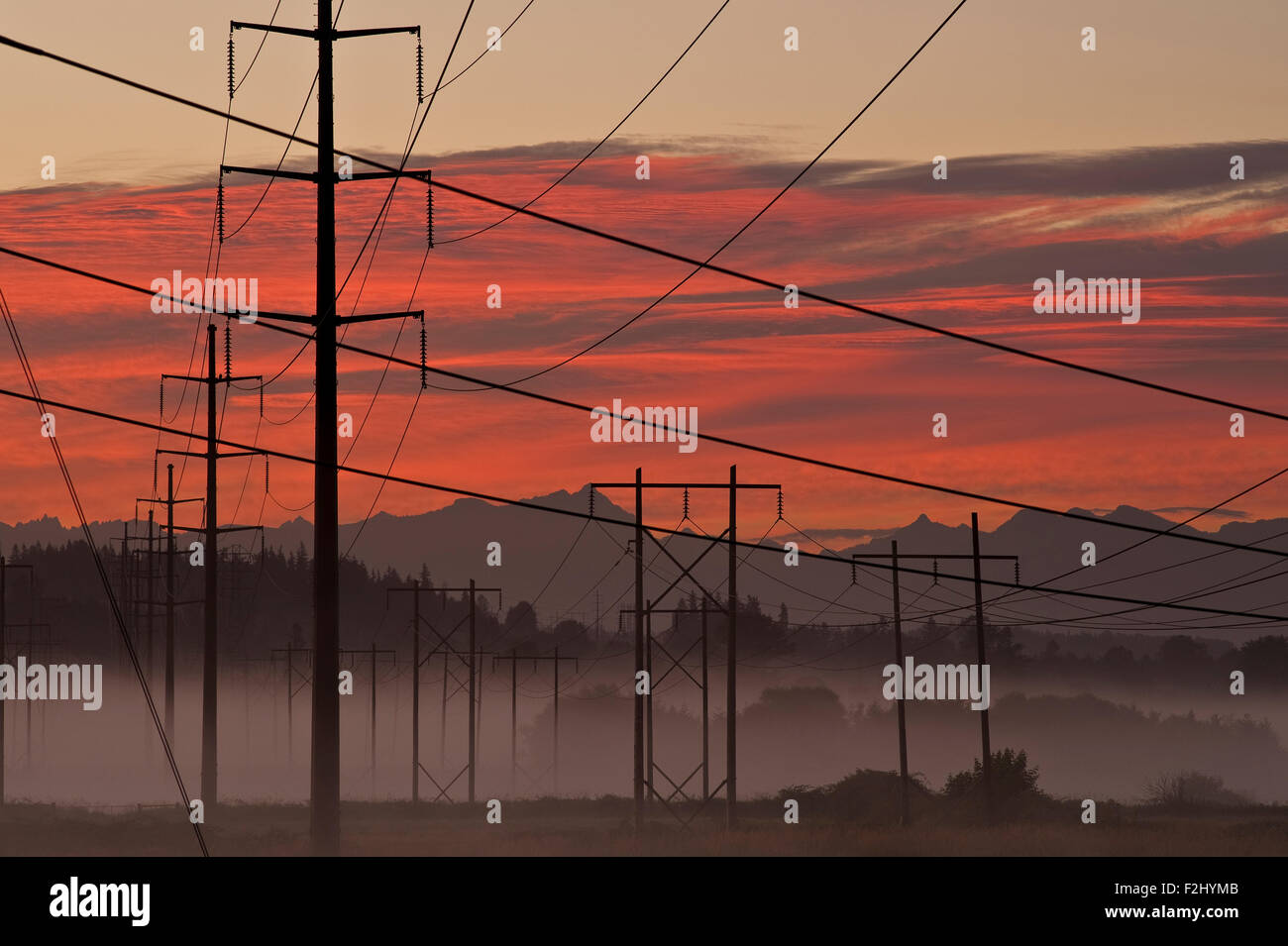 Sunrise with power lines and telephone wires stretching across valley ...