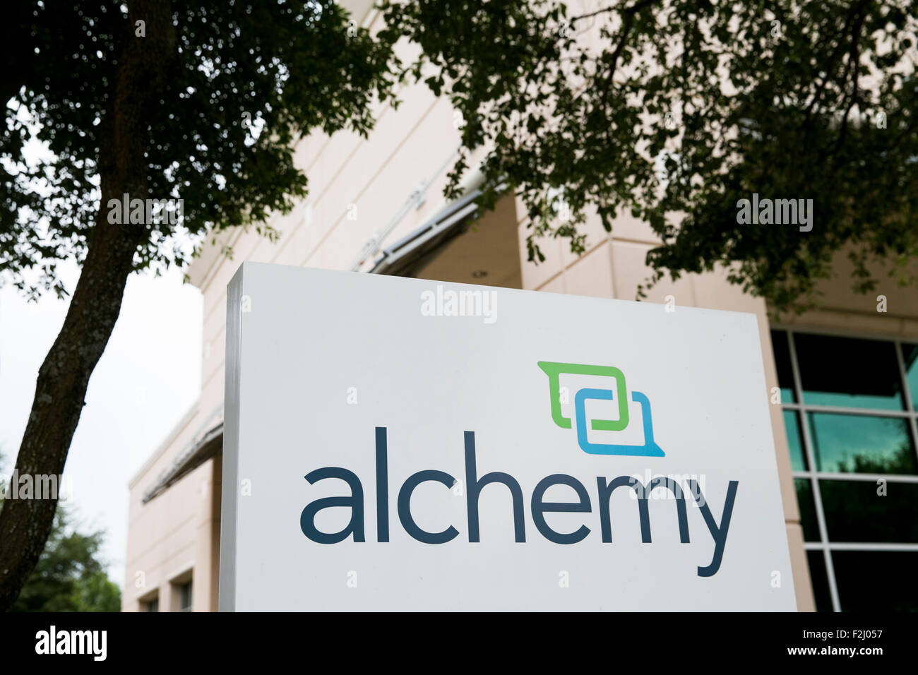 A logo sign outside of the headquarters of Alchemy Systems, LP, in ...