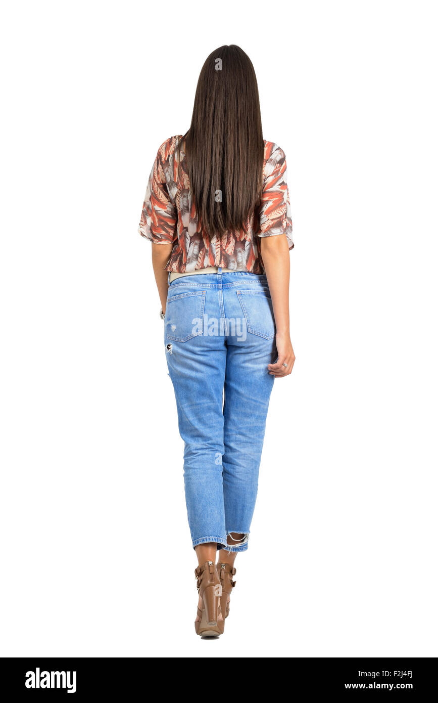 Rear view of woman with long hair in casual clothes walking away. Full ...