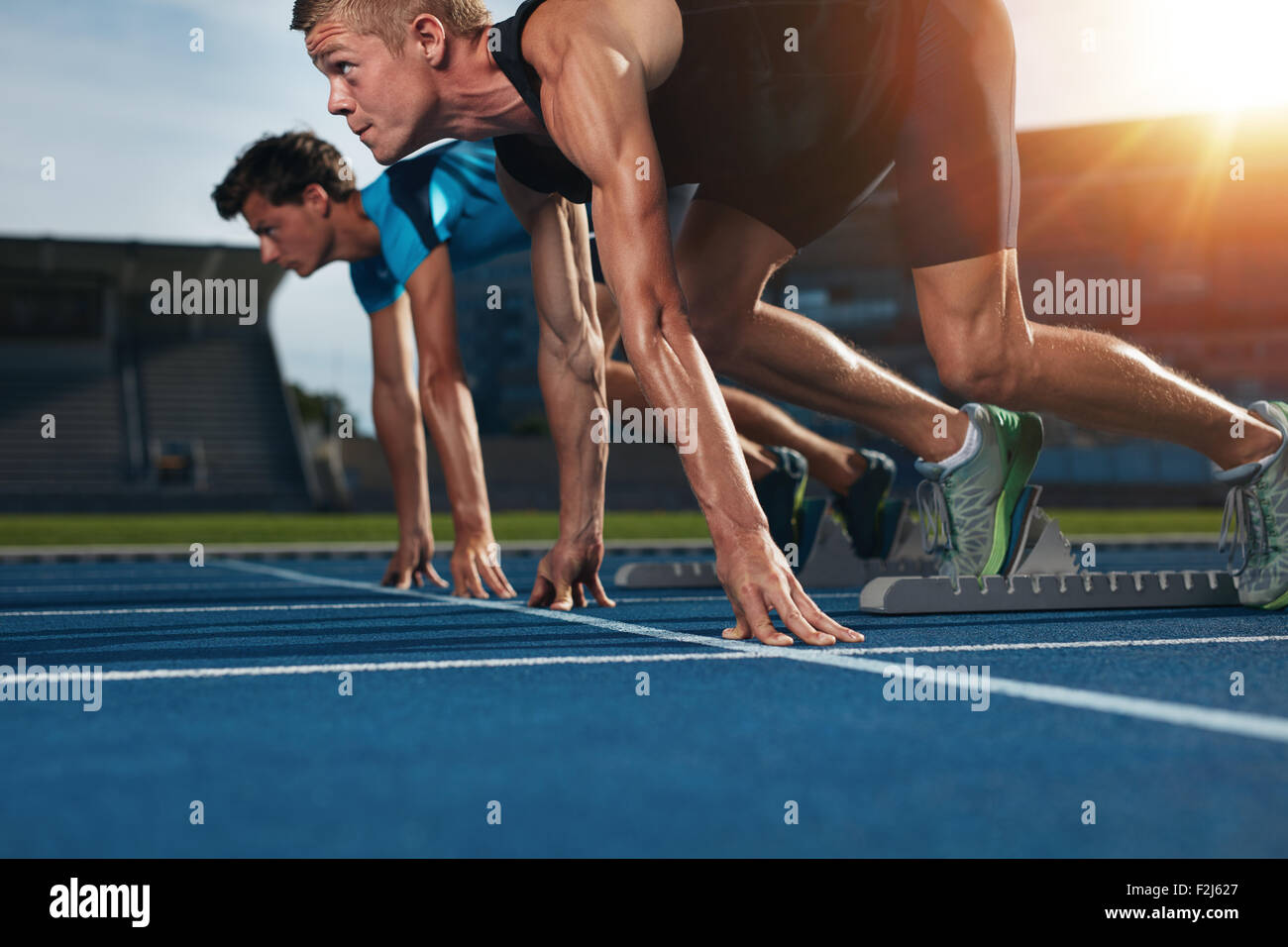Two young athletes at starting position ready to start a race ...