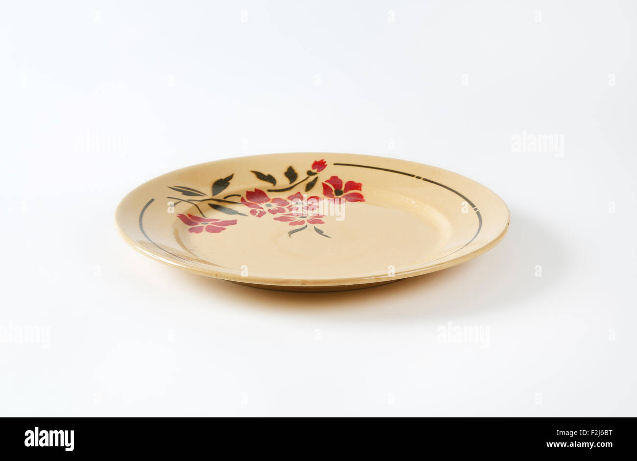 beige plate with floral pattern on white background Stock Photo - Alamy