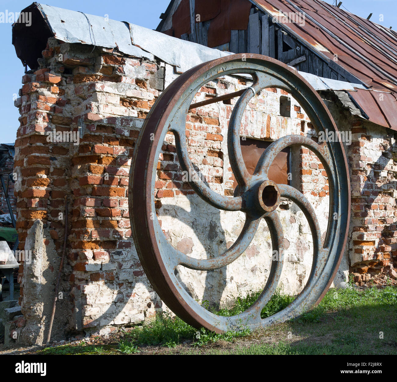 Large rusted metal industrial wheel as a decoration, against the ...