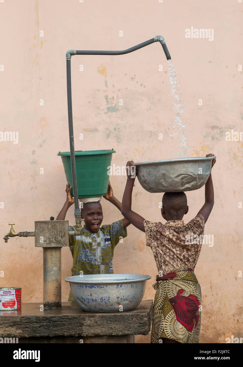 Benin, West Africa, Porto-Novo, children collecting water in the street ...