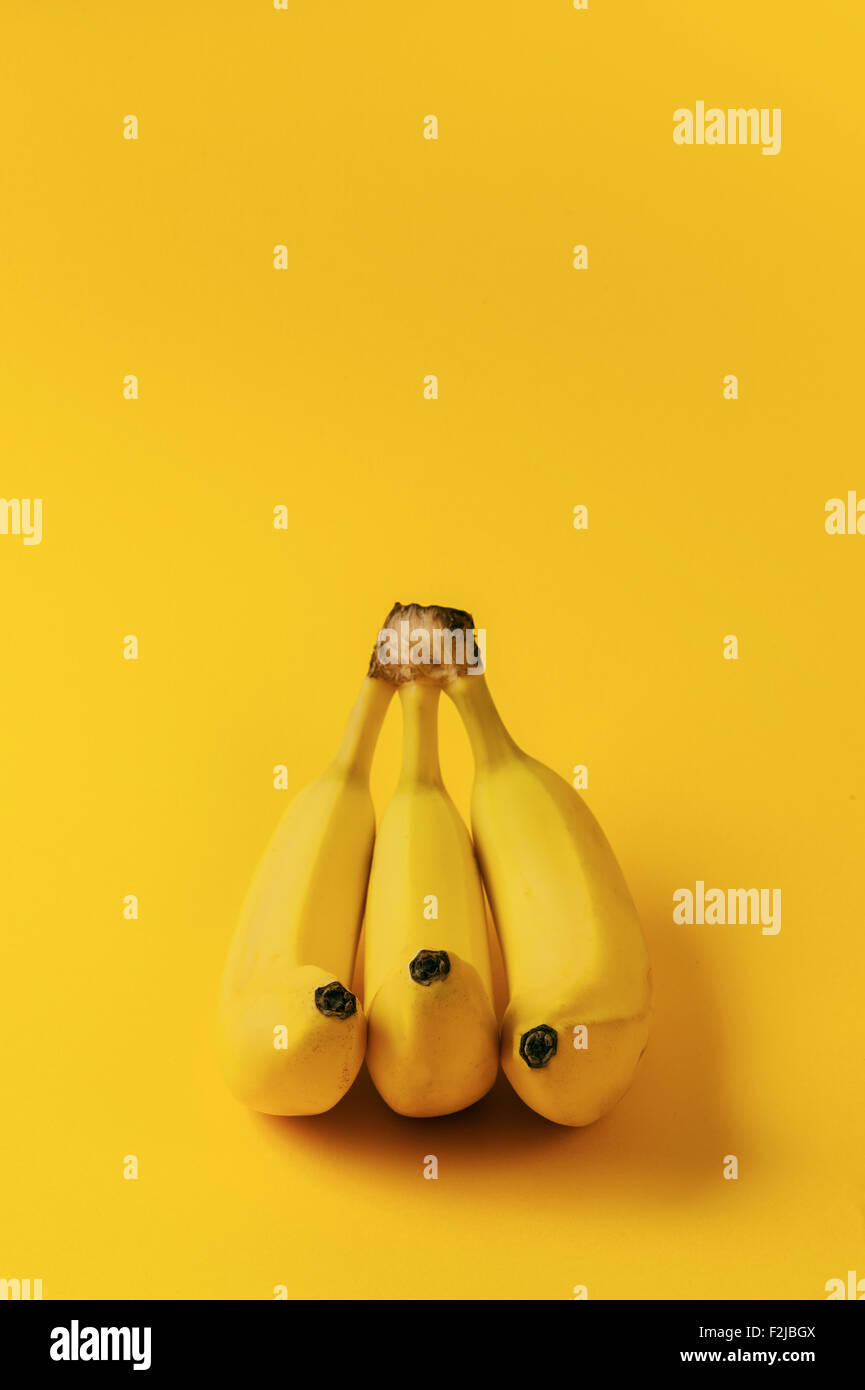 Three ripe bananas on the yellow background Stock Photo - Alamy