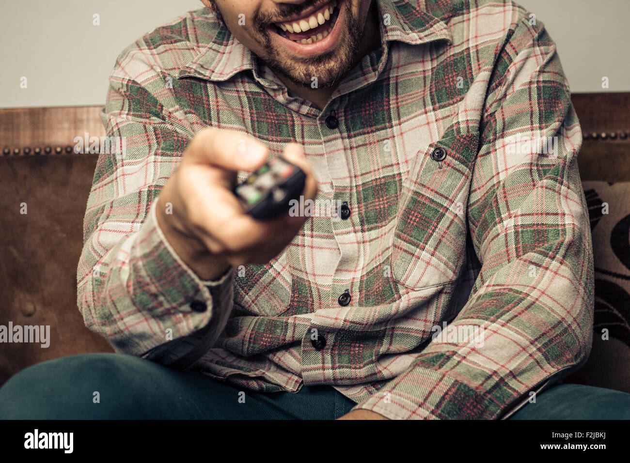 Laughing man changing channel Stock Photo - Alamy