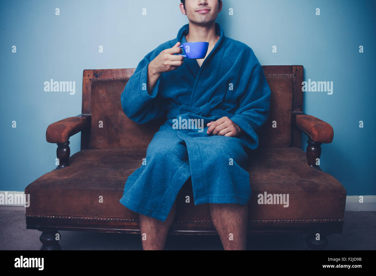 Young man in bathrobe drinking coffee at home Stock Photo - Alamy
