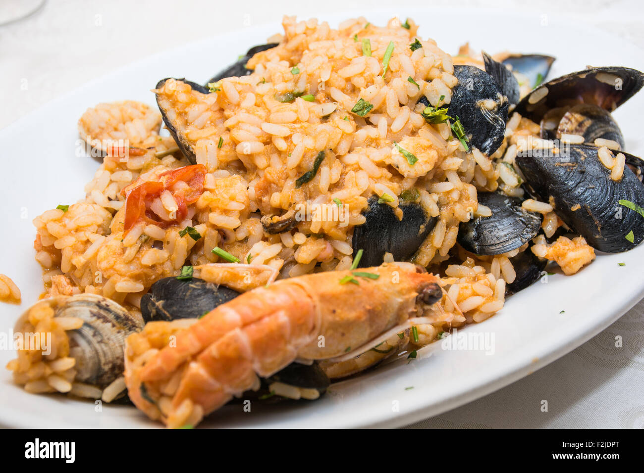 A dish of seafood rice pics, with mussels, clams, shrimp, mussels ...