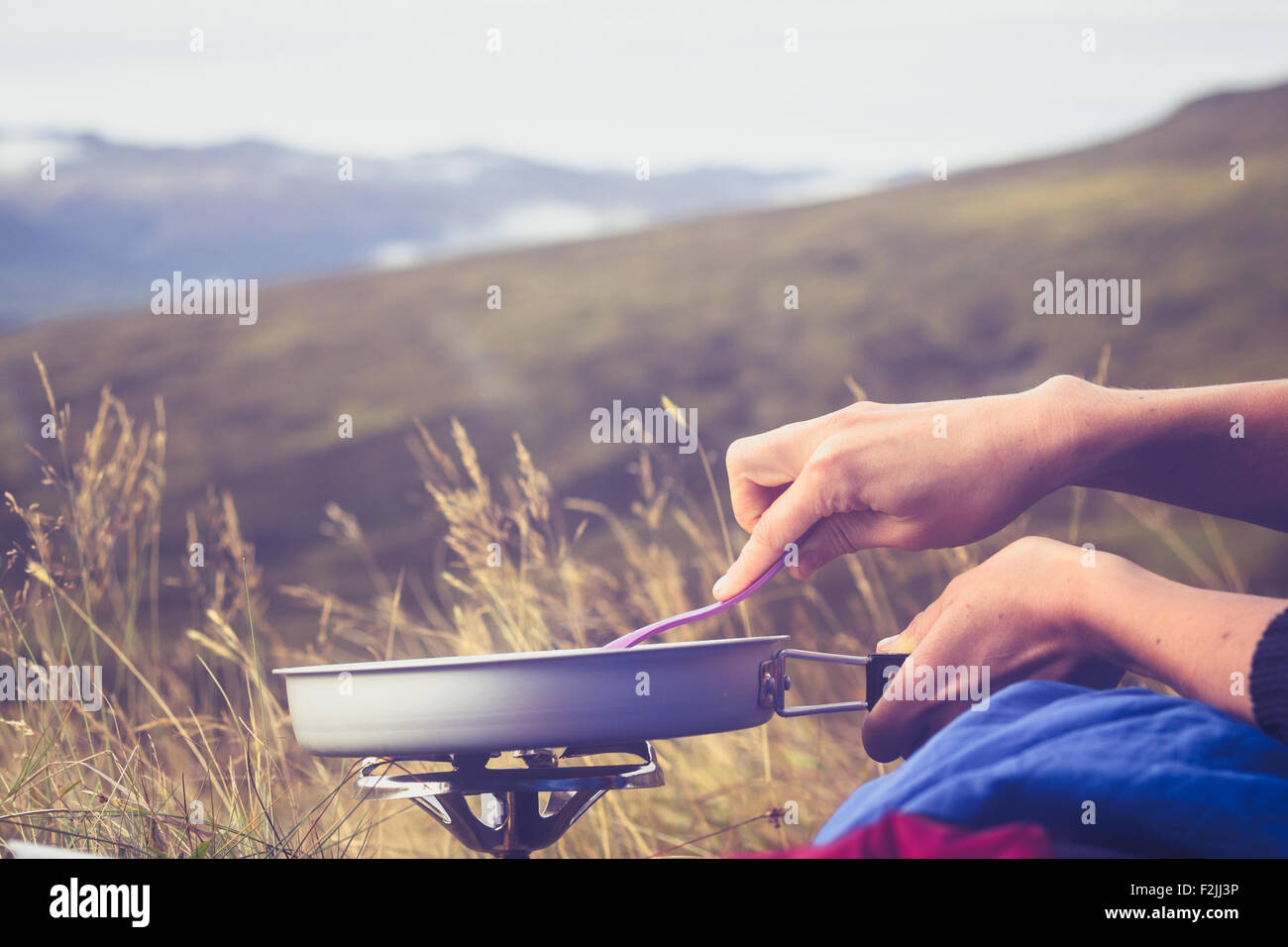 Female hands cooking with camping stove in nature Stock Photo - Alamy
