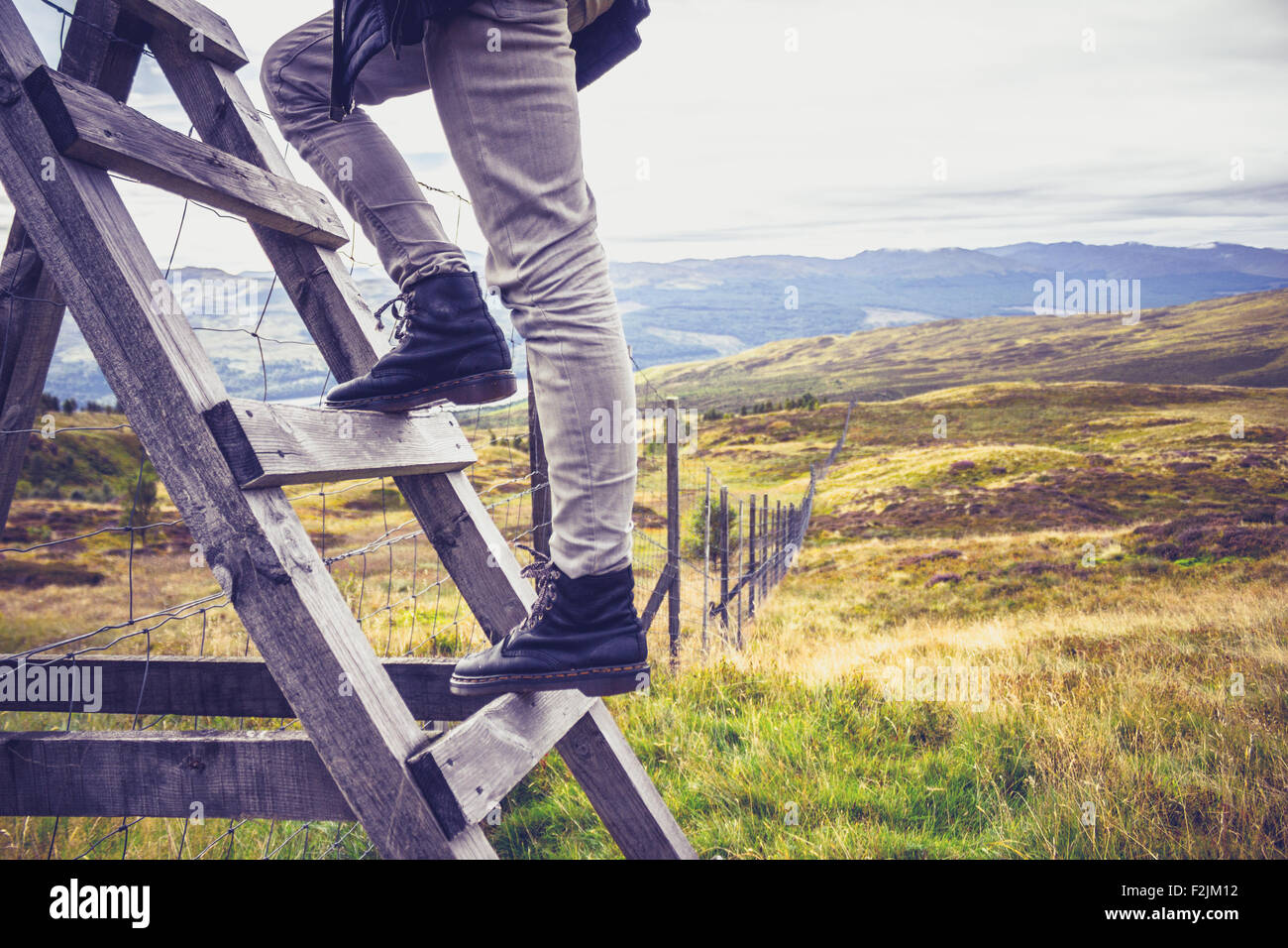 Woman climbing fence hi-res stock photography and images - Alamy