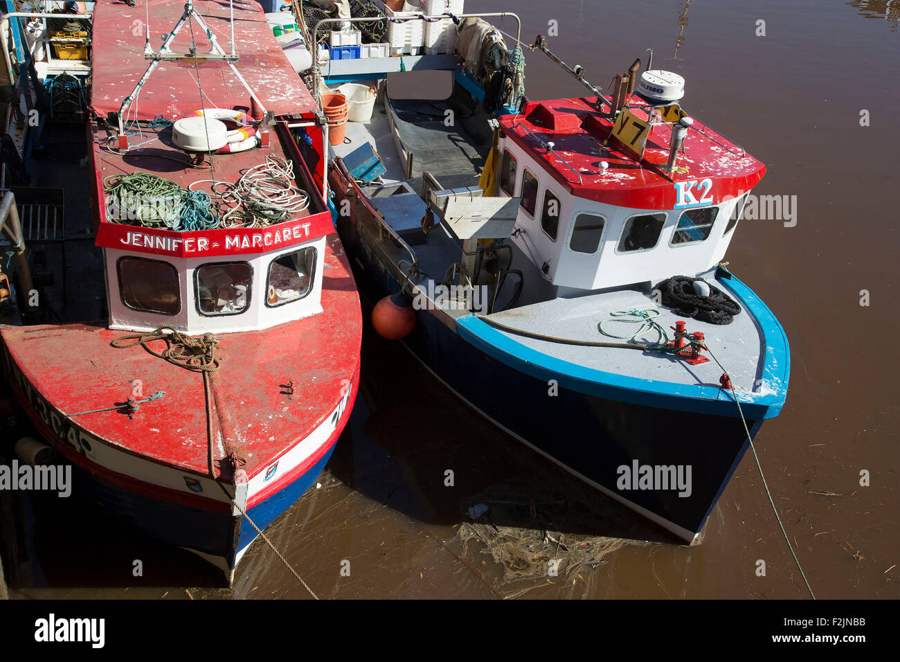Fishing boats moored at the quayside in the harbour in Whitby, a ...