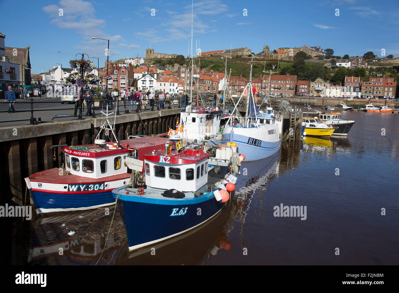 Fishing boats moored at the quayside in the harbour in Whitby, a ...