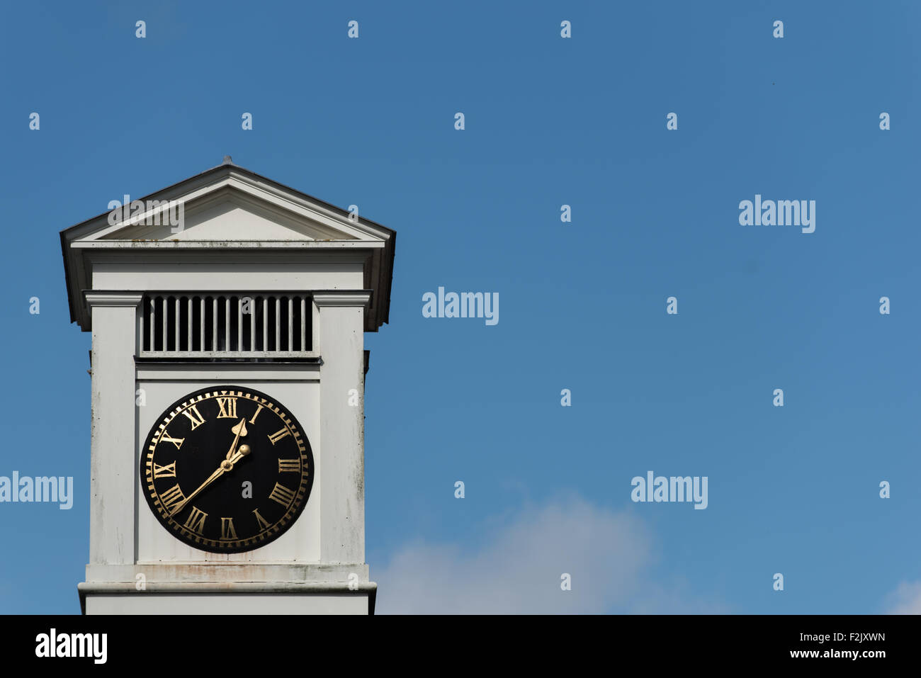 a roman numeral clock tower with a blue sky and white cloud background ...