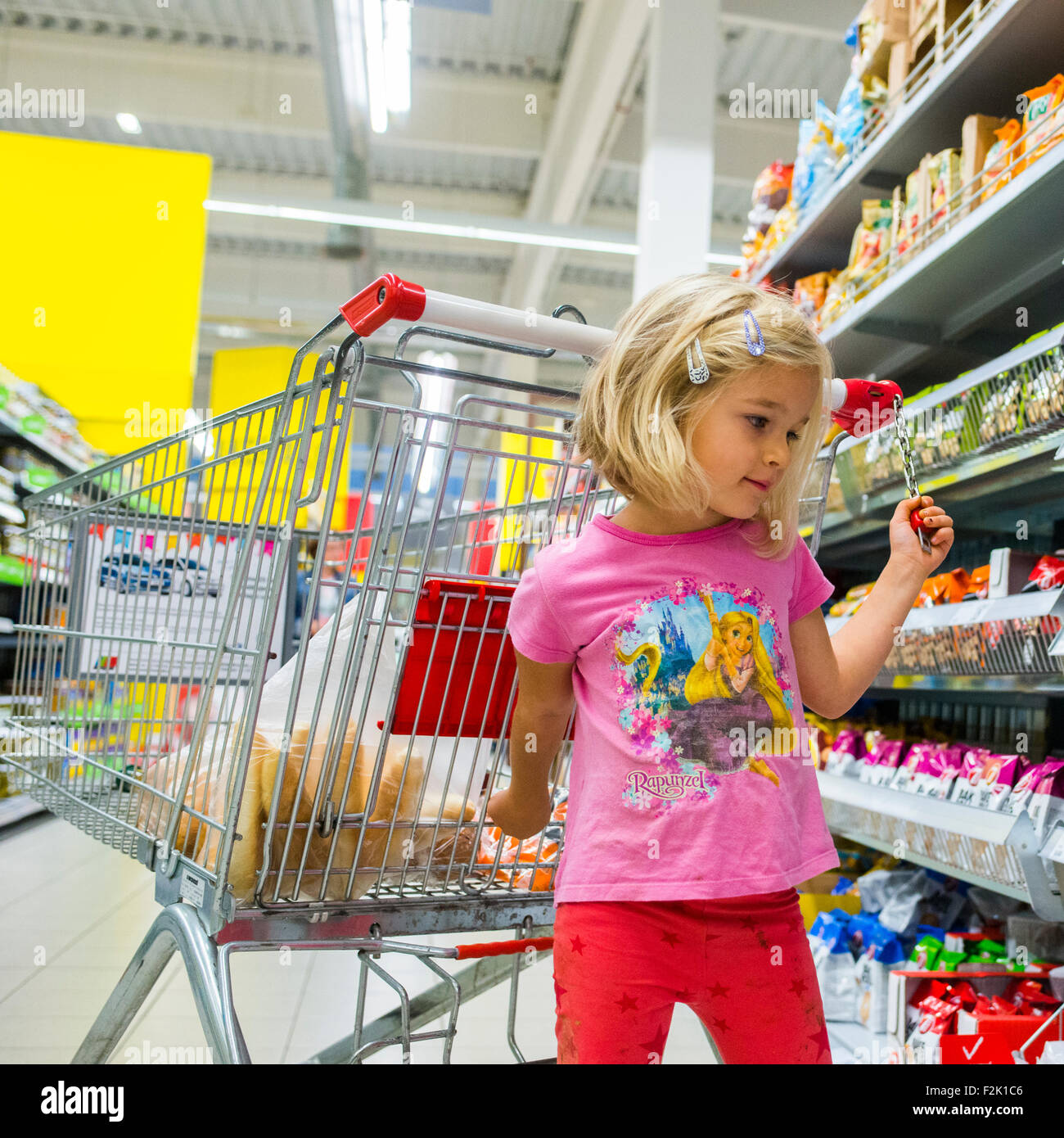 Little Child Blond Girl Shopping in the supermarket, pushing trolley ...