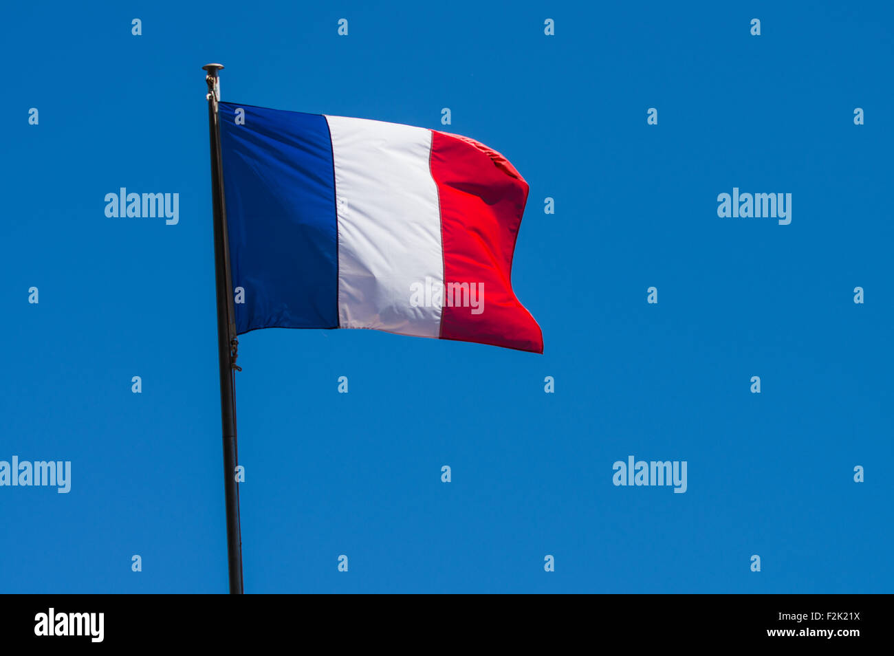 French flag against blue cloudy sky on street Stock Photo - Alamy