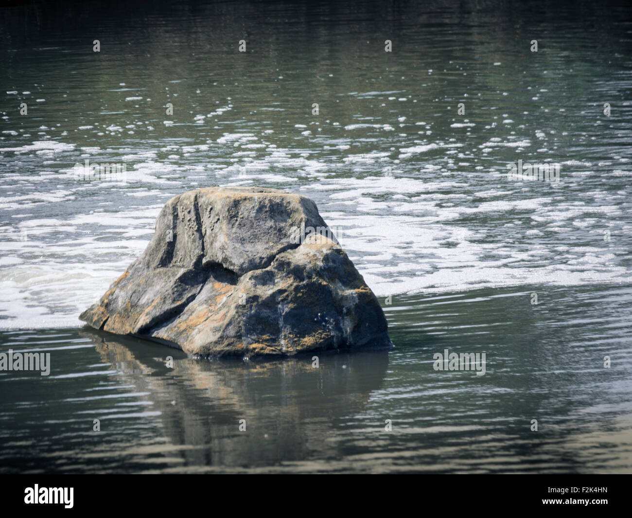 big rock on water Stock Photo - Alamy
