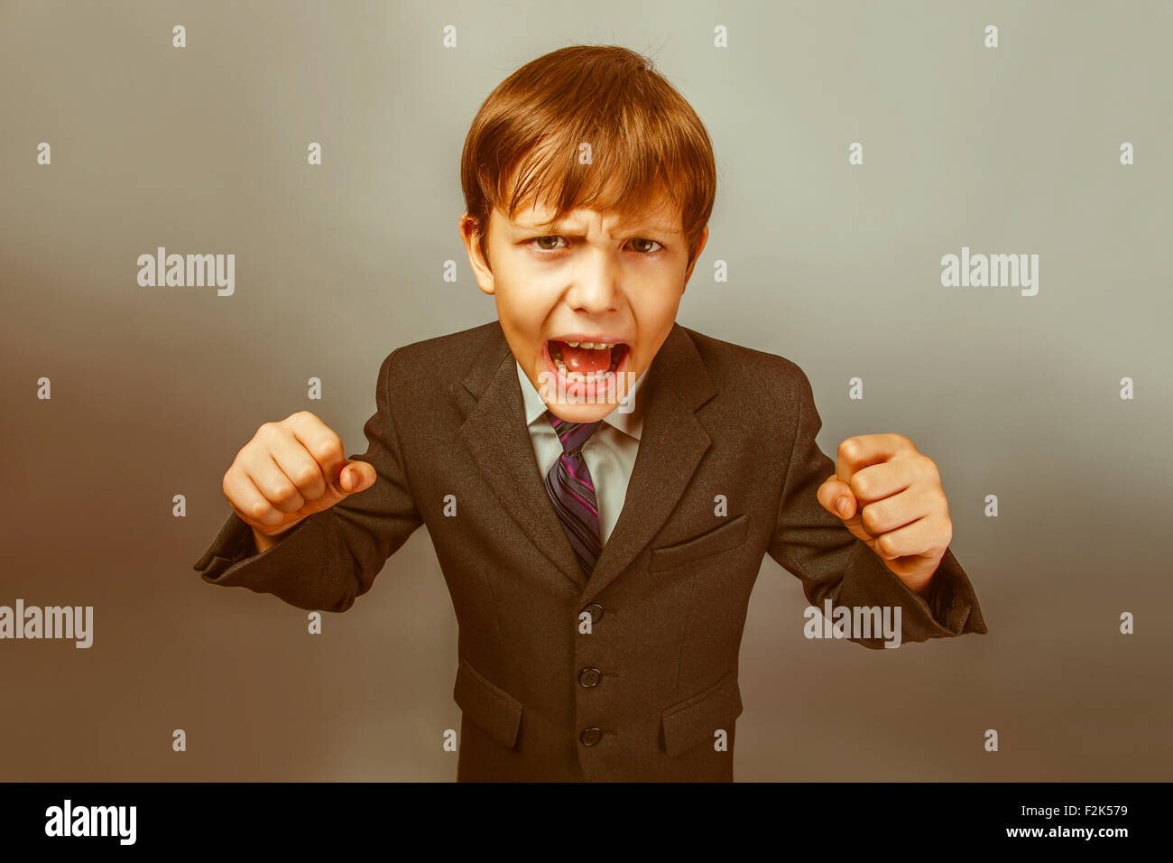 a boy of twelve European appearance in a suit shouting angry on Stock ...