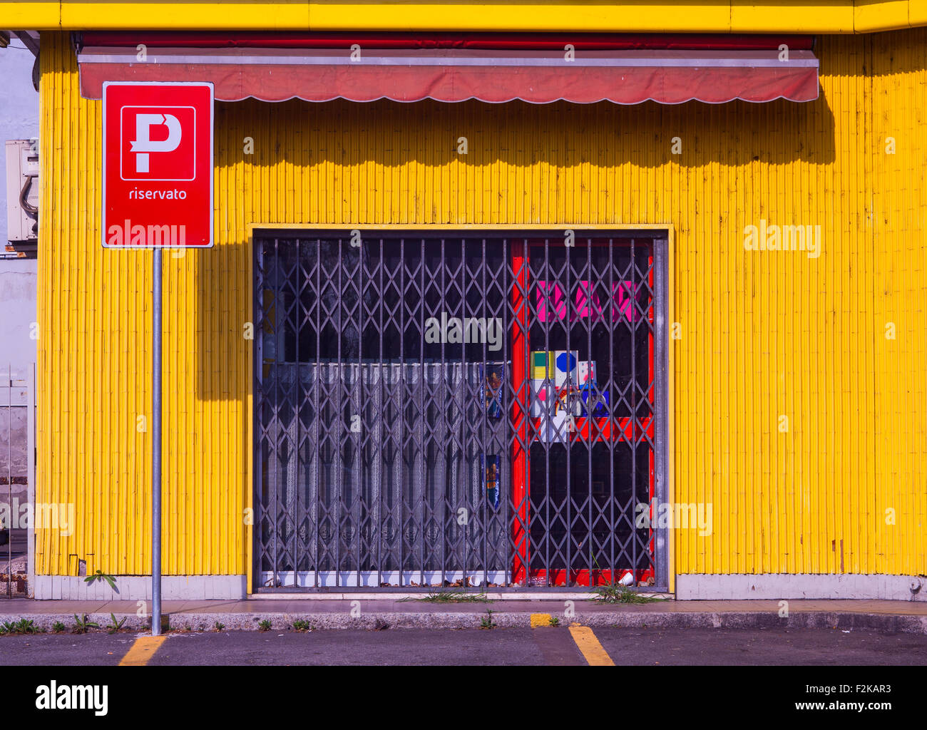 Gate of closed shop with yellow wall Stock Photo - Alamy